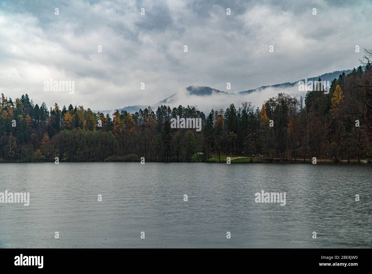 Coastline of Bled lake, mountains with forest and mist. Fall in Bled ...