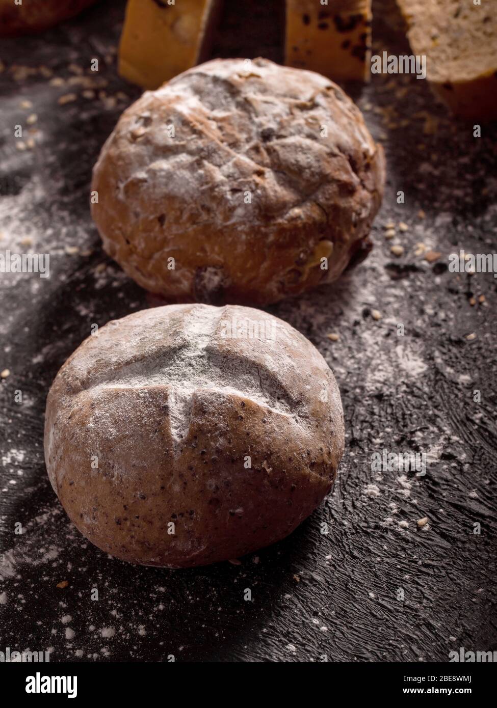 Close-up the rustic loaves of bread placed on wooden black background ...