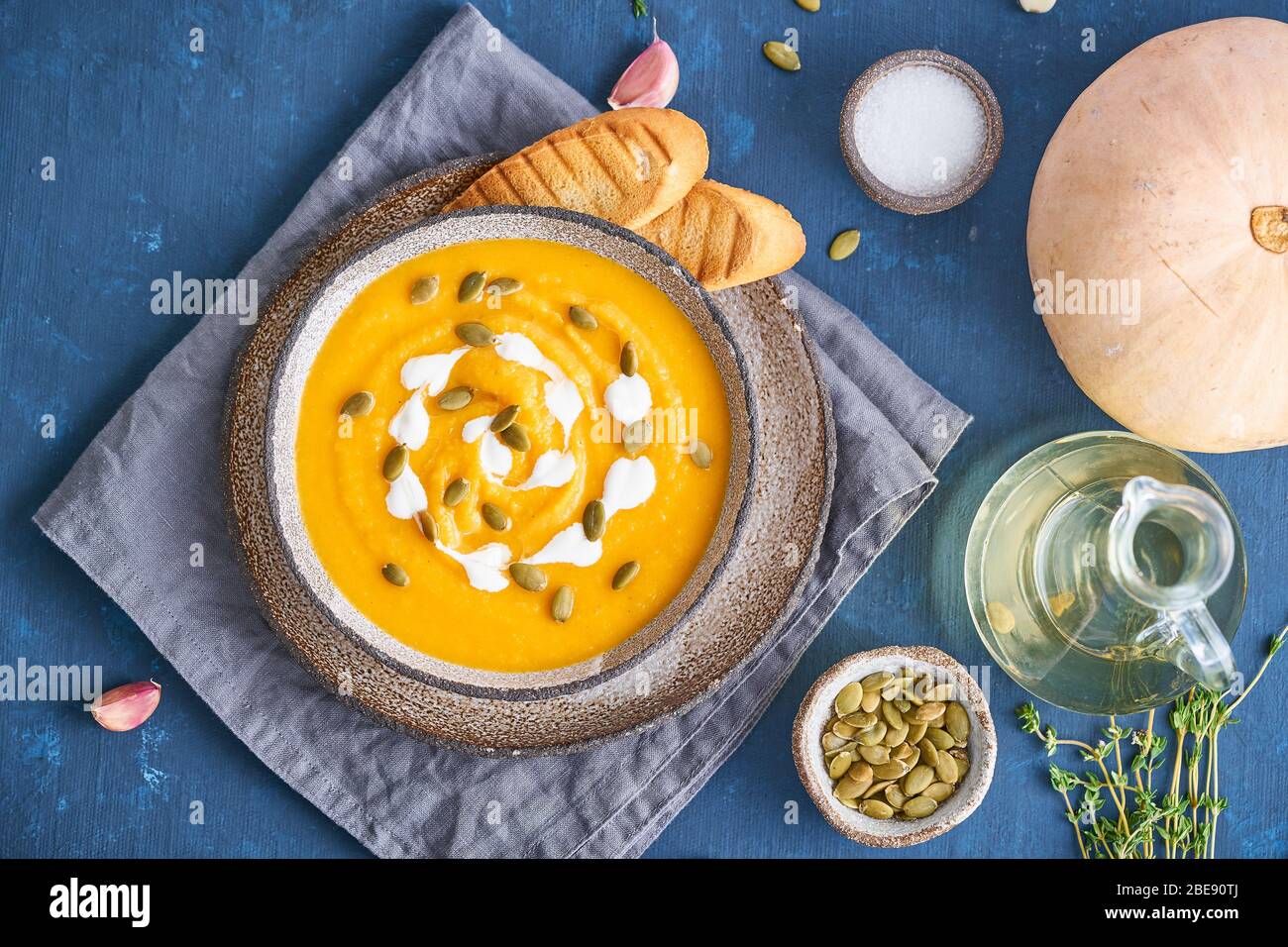 Pupmkin cream soup puree on dark bright blue wooden table, dietary ...