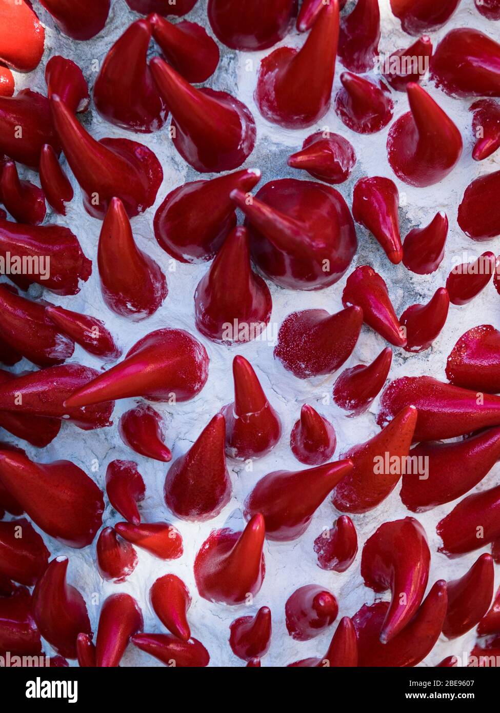 Texture formed by pointed and curved red spines on a white background ...