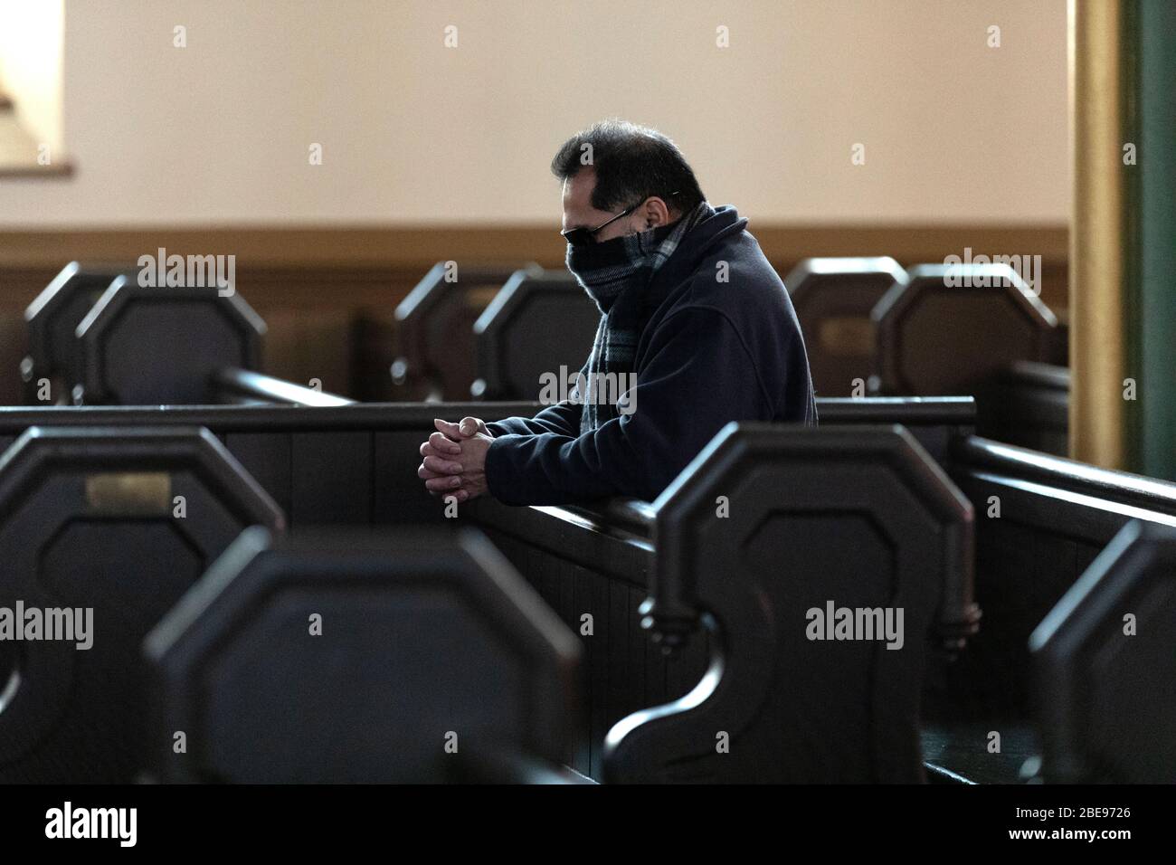 A lone person wearing a protective face mask praying in Most Holy ...