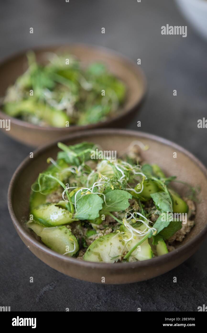 Green healthy vegetables, pea shoots, courgettes, sprouts in bowls ...