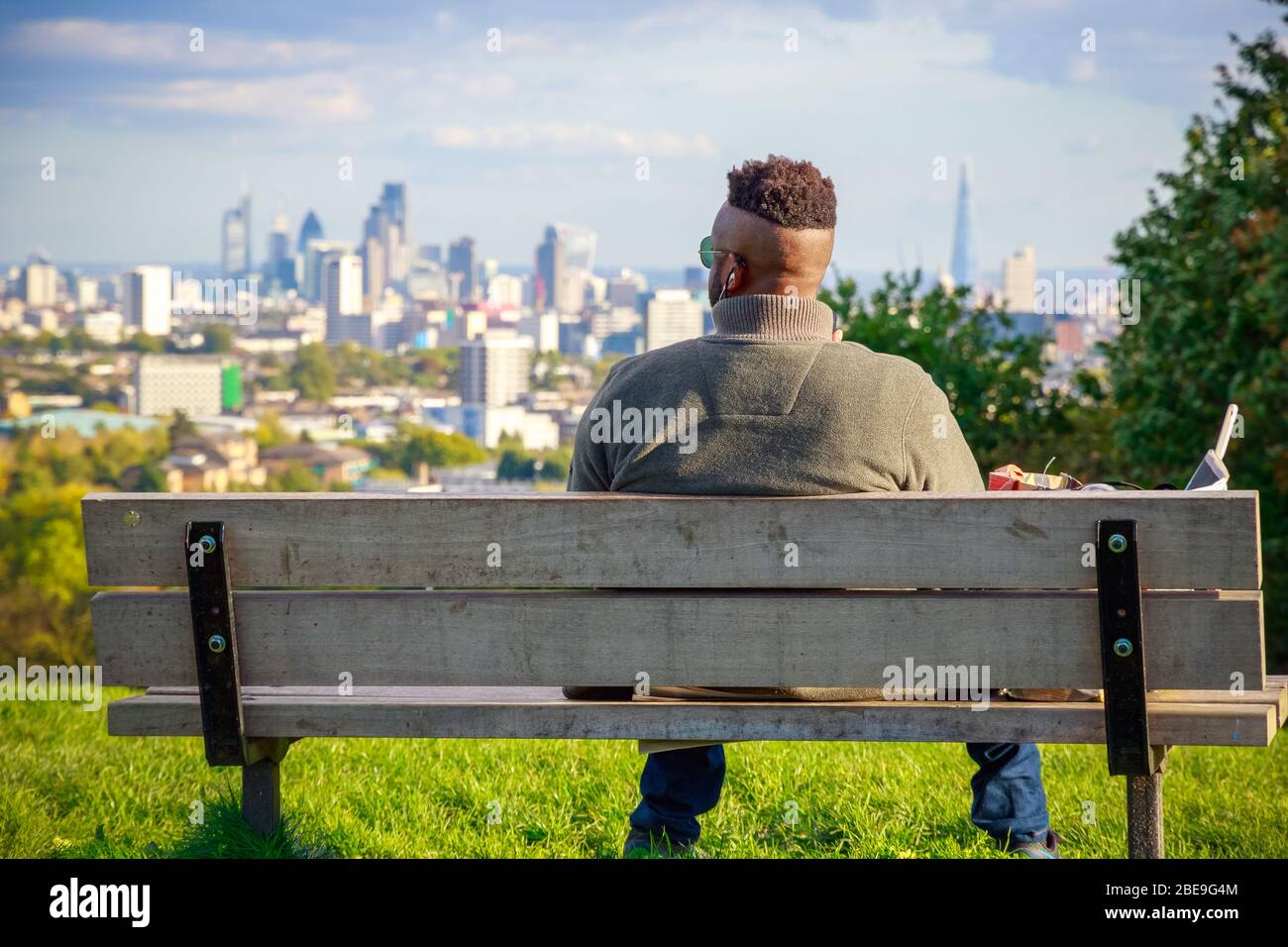 Back view of a tourist looking over London city skyline from Parliament ...