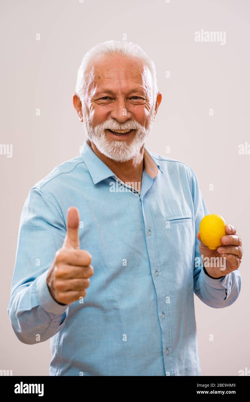 Portrait of cheerful senior man who is holding lemon and smiling Stock ...