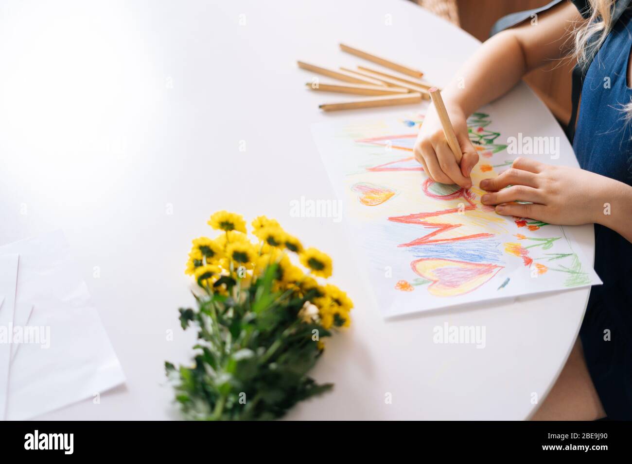 Close-up of hands of unrecognizable girl drawing with colored pencils ...