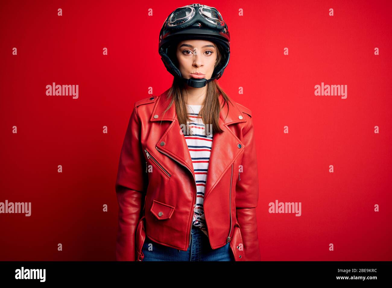 Young beautiful brunette motocyclist woman wearing motorcycle helmet ...