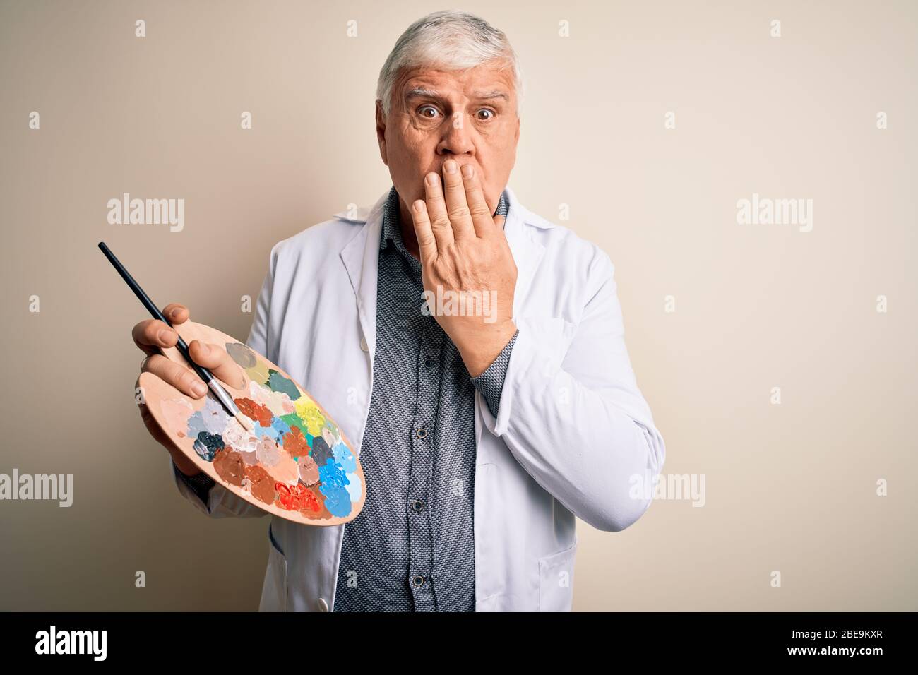 Senior handsome hoary painter man painting using brush and palette with ...