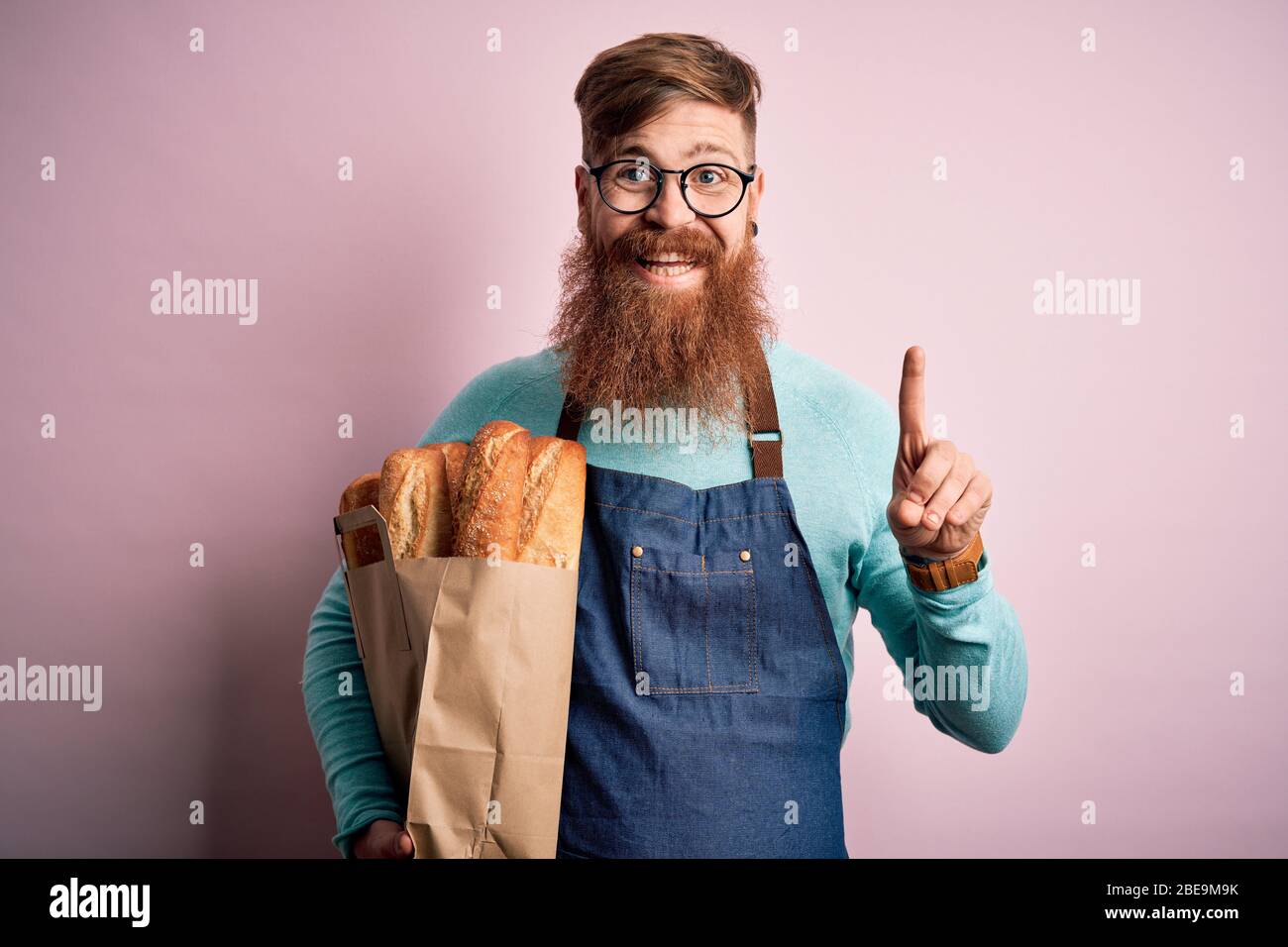 Irish redhead baker man with beard holding groceries paper bag of bread ...