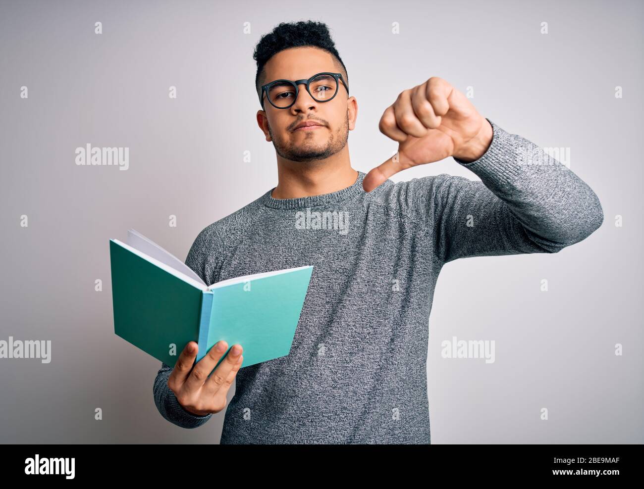 Young handsome smart student man reading book over isolated white ...