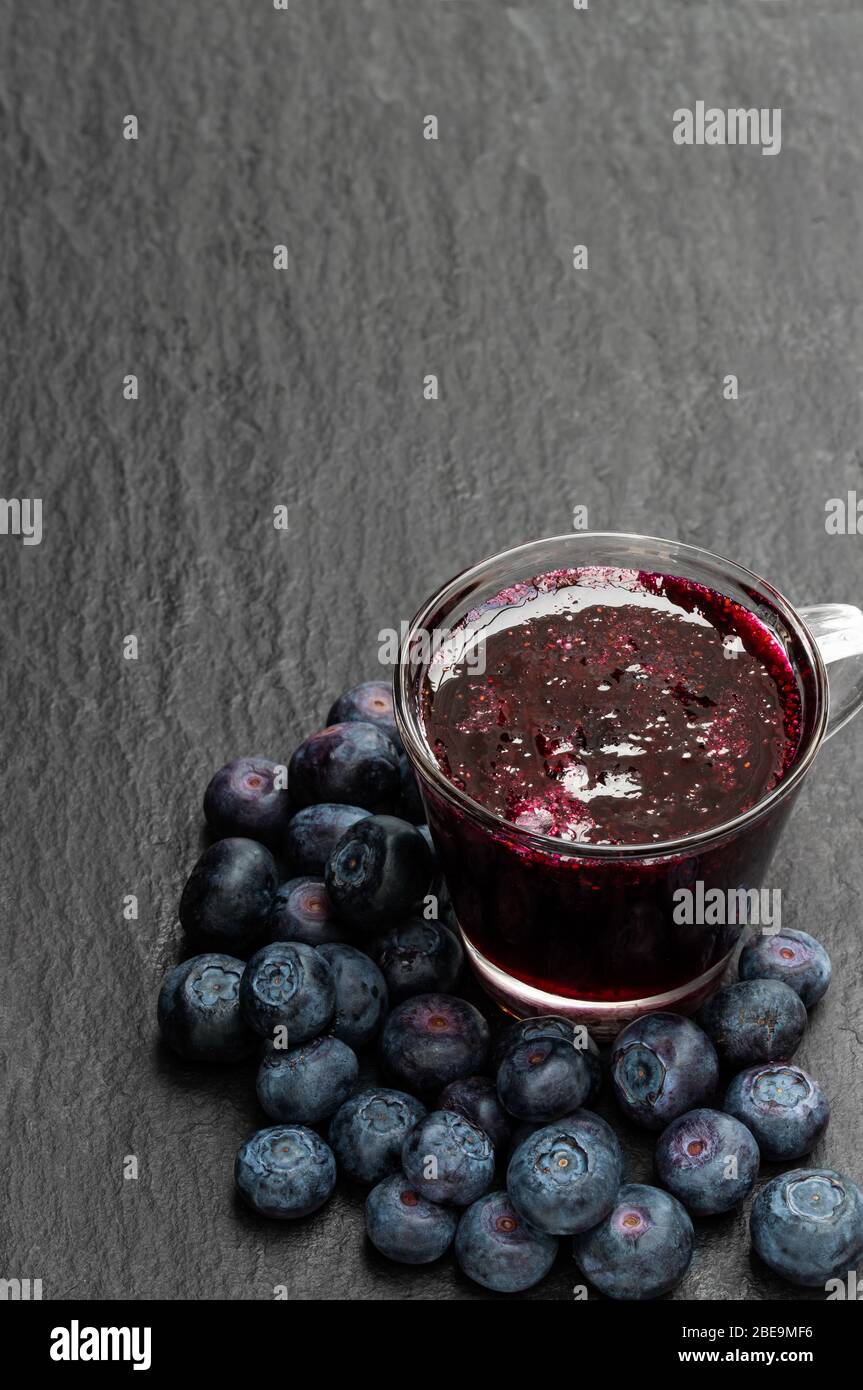 Homemade blueberry jam in glass cup on black stone background Stock ...