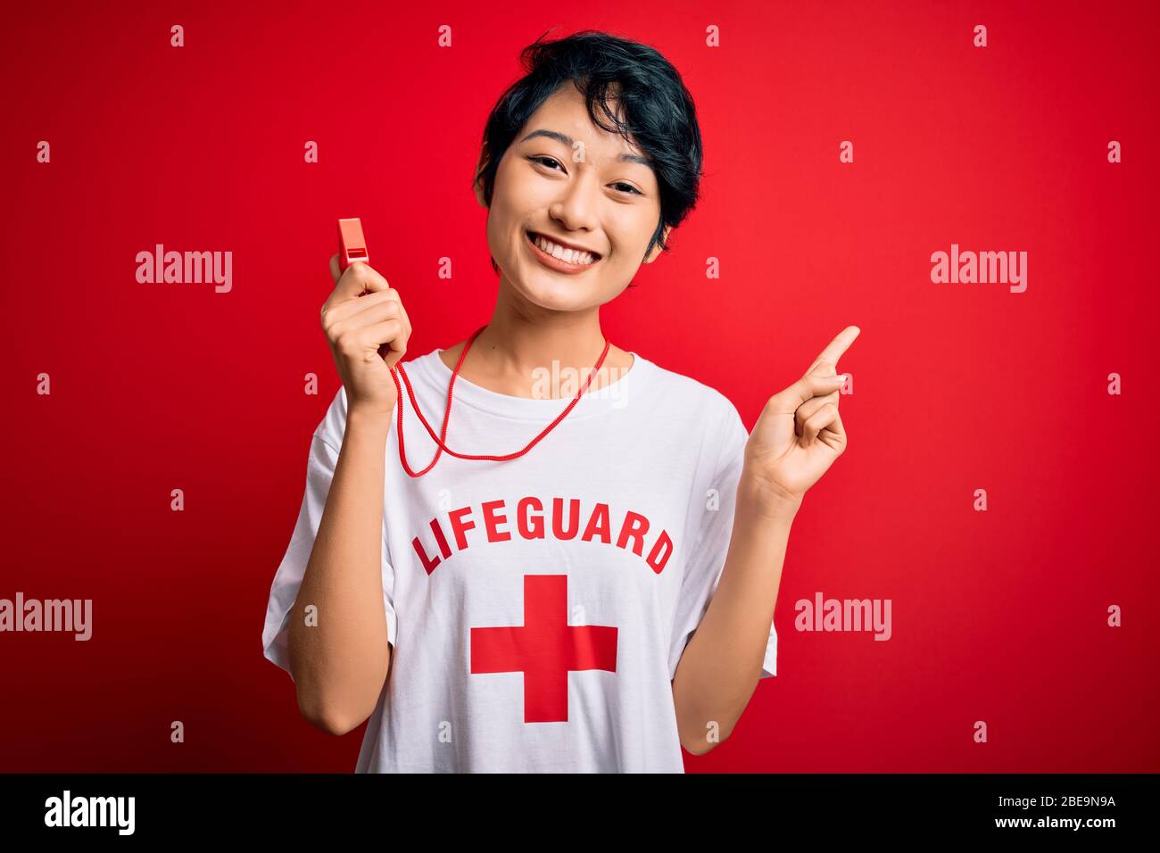 Young beautiful asian lifeguard girl wearing t-shirt with red cross ...