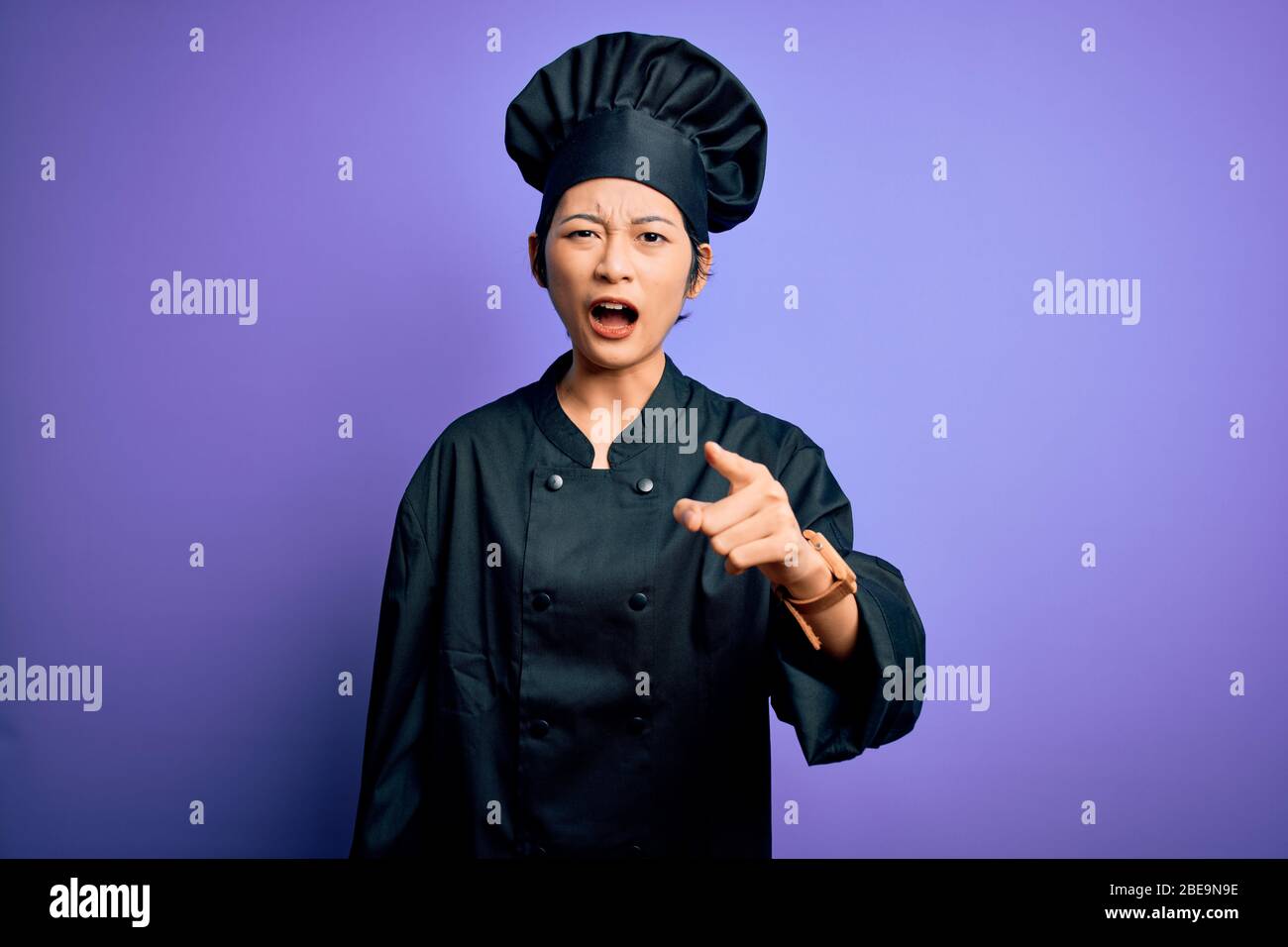 Young beautiful chinese chef woman wearing cooker uniform and hat over ...