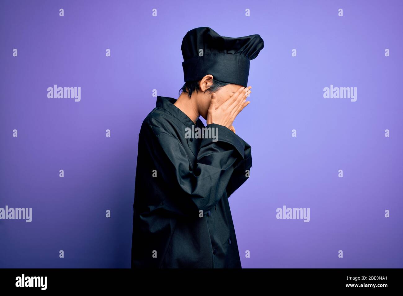 Young beautiful chinese chef woman wearing cooker uniform and hat over ...