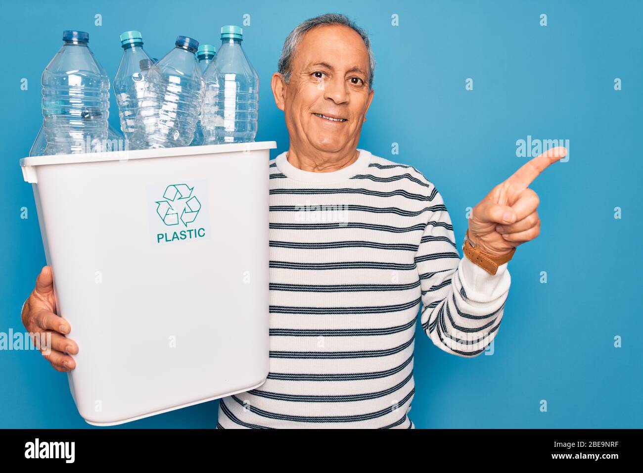 Senior man recycling holding trash can with plastic bottles to recycle ...