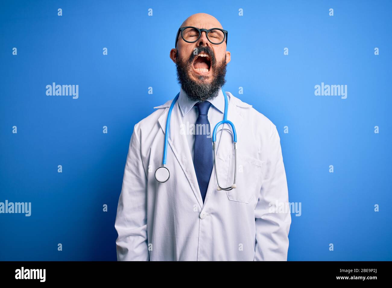 Handsome bald doctor man with beard wearing glasses and stethoscope ...