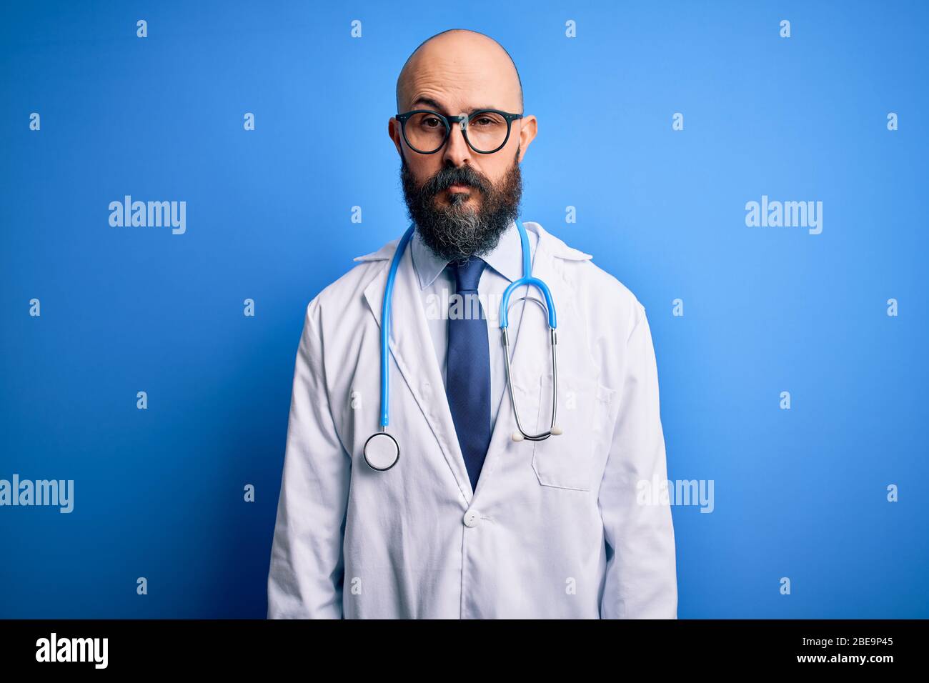 Handsome bald doctor man with beard wearing glasses and stethoscope ...