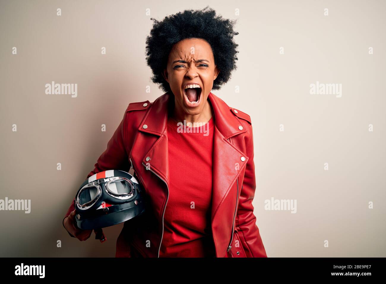Young African American afro motorcyclist woman with curly hair holding ...