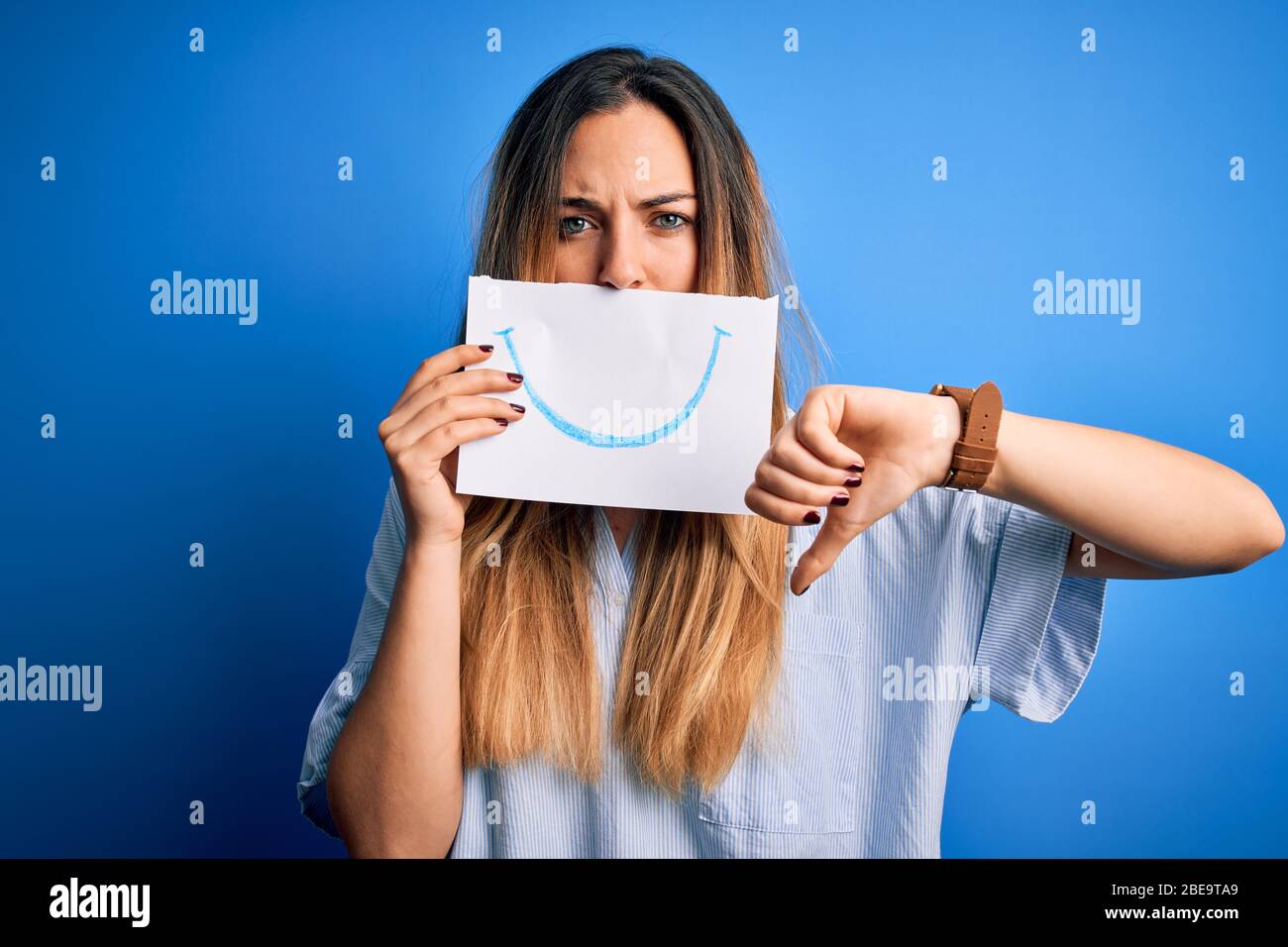 Young beautiful brunette woman holding card with smile illustration on ...