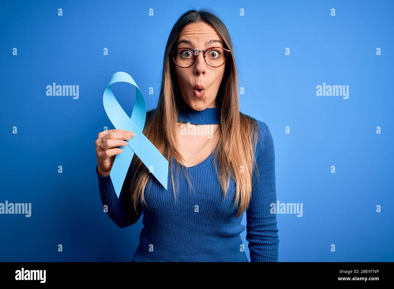 Young blonde woman with blue eyes holding colon cancer awareness blue ...