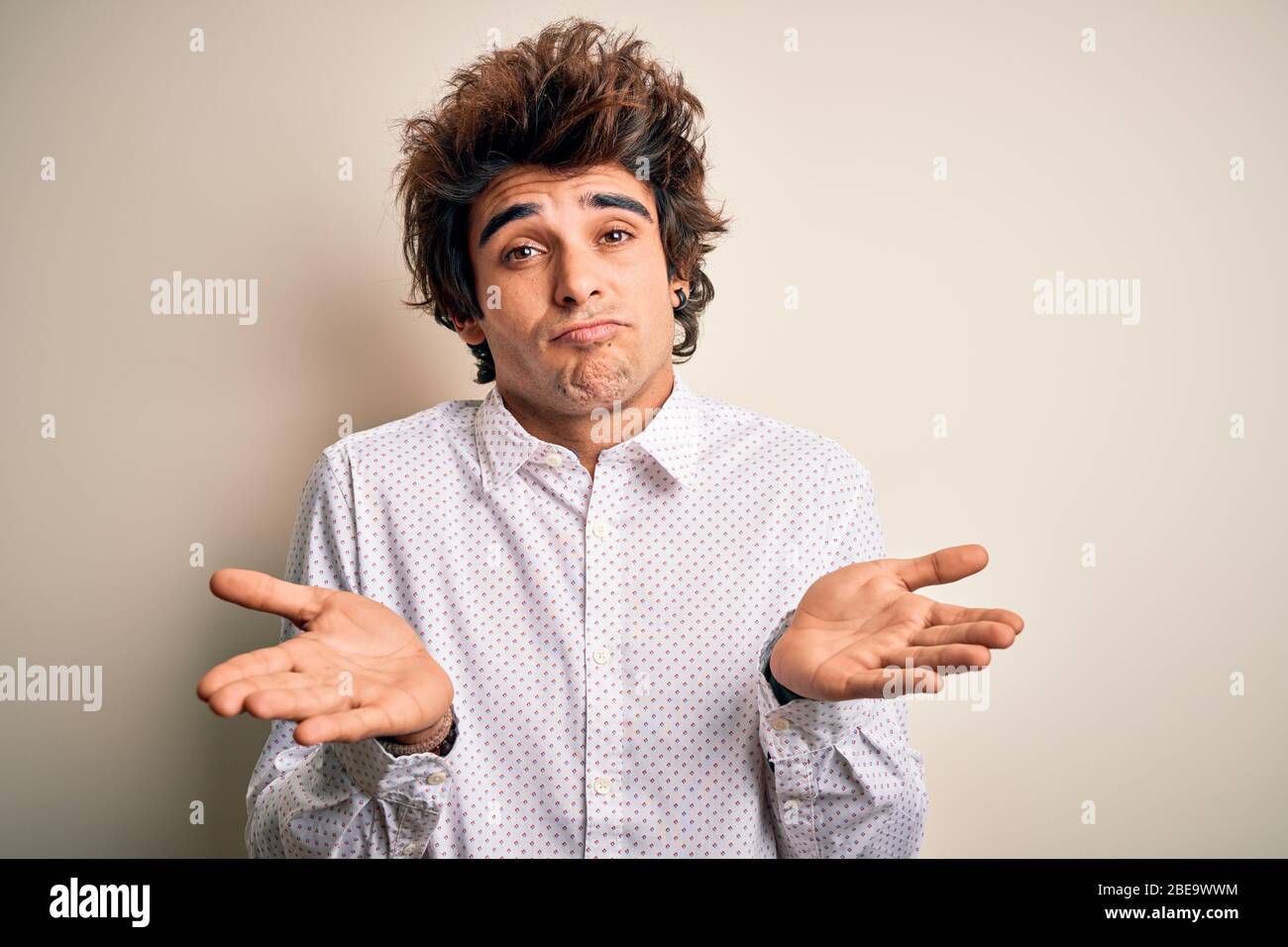 Confused businessman shrugging with raised arms hi-res stock ...