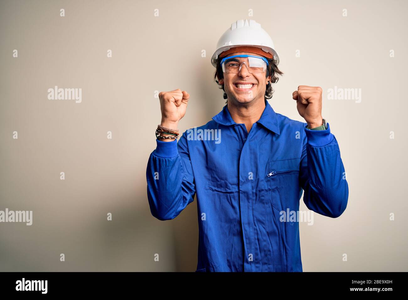 Young constructor man wearing uniform and security helmet over isolated ...