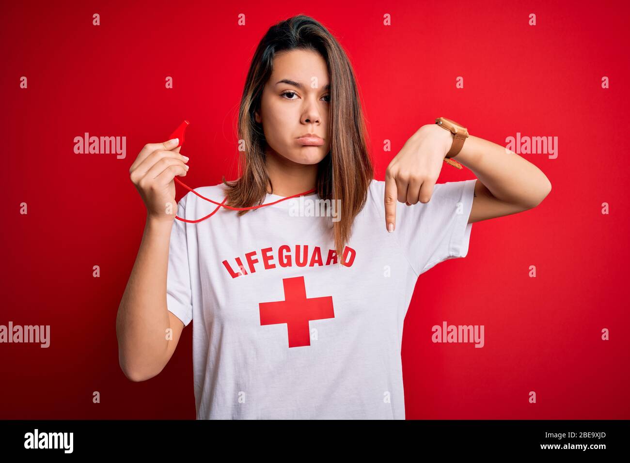 Young beautiful brunette lifeguard girl wearing t-shirt with red cross ...