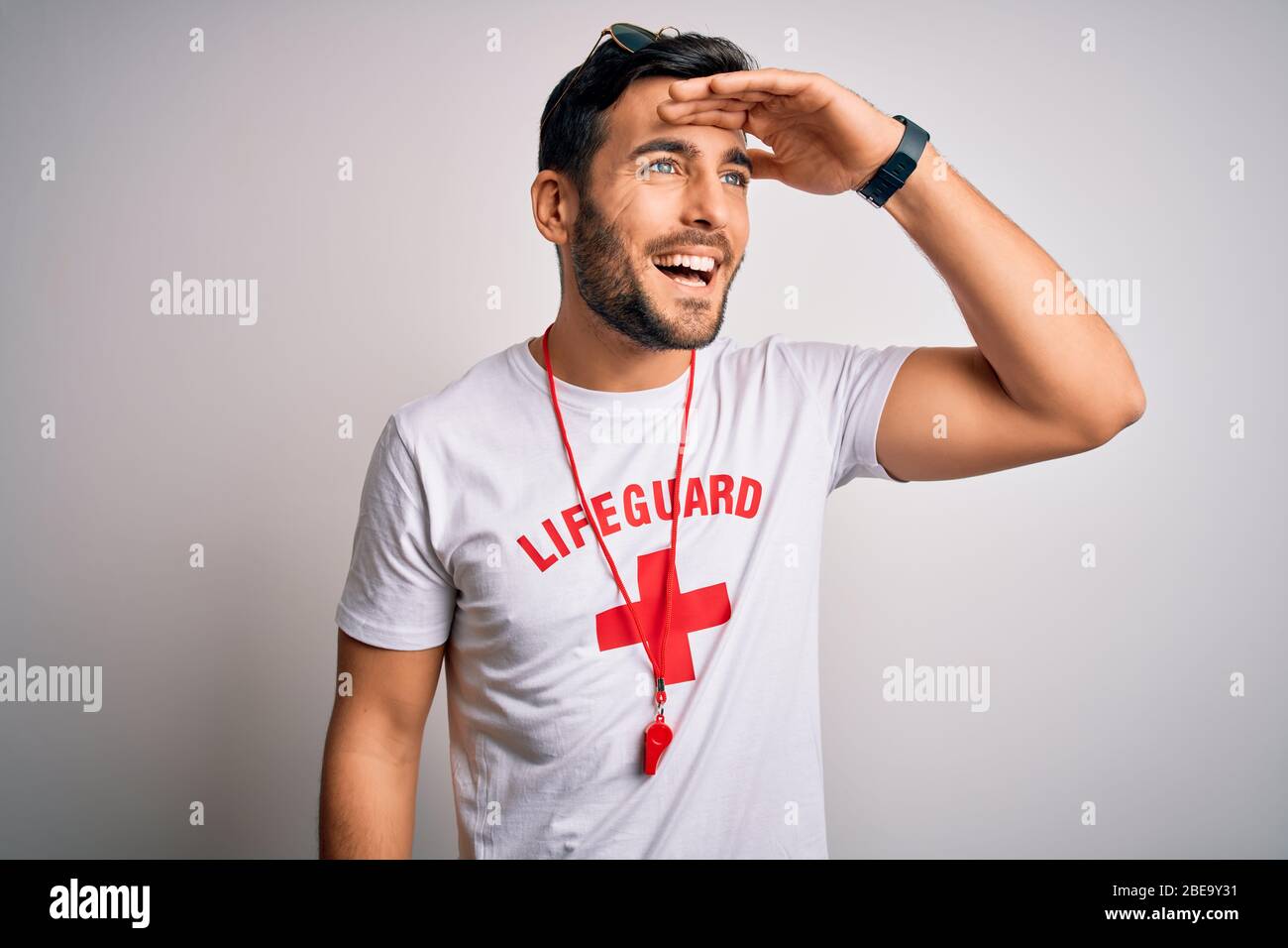 Young handsome lifeguard man with beard wearing t-shirt with red cross ...