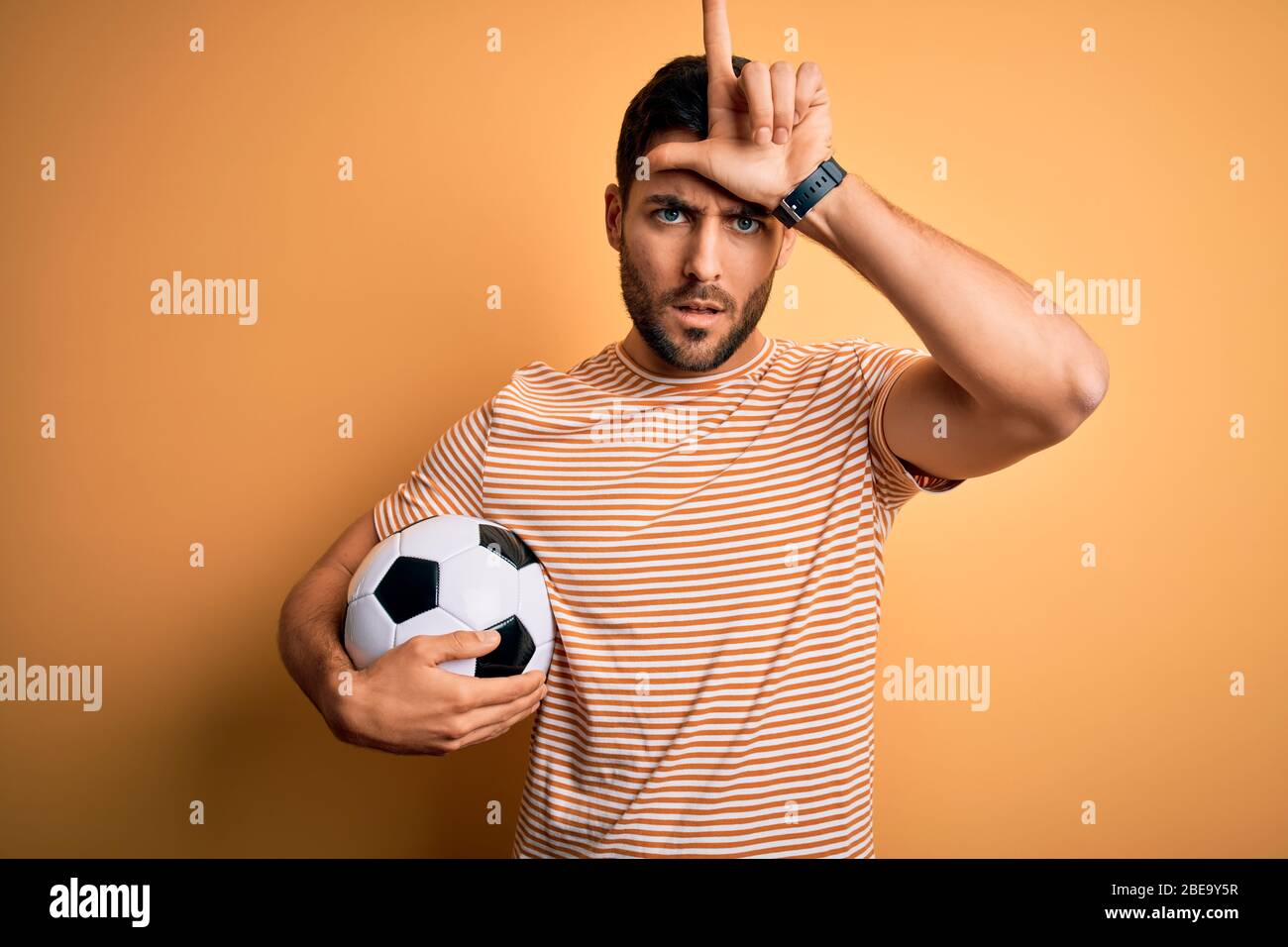 Handsome player man with beard playing soccer holding footballl ball ...