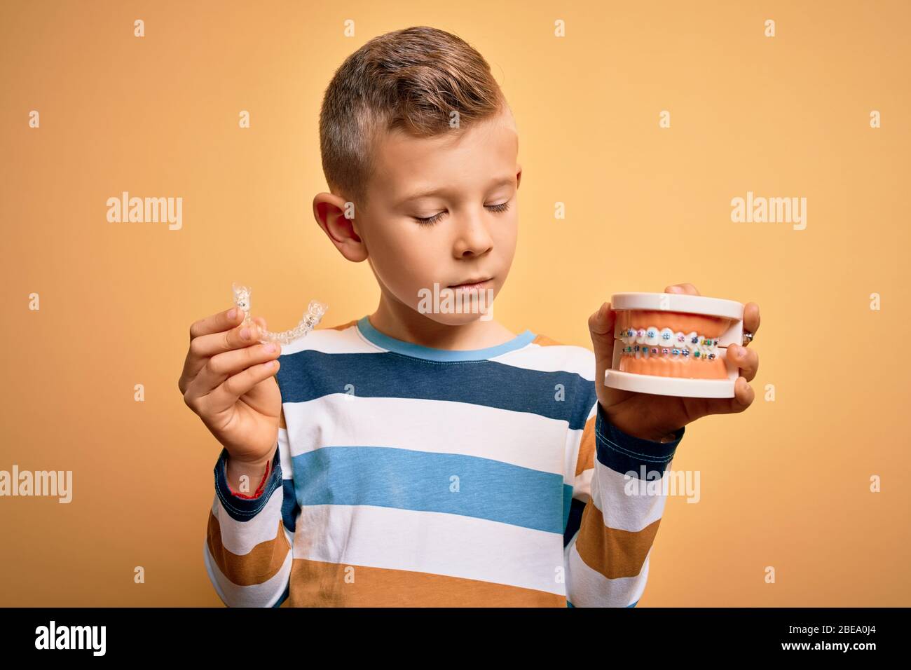 Little kid boy holding professional orthodontic denture with metal ...