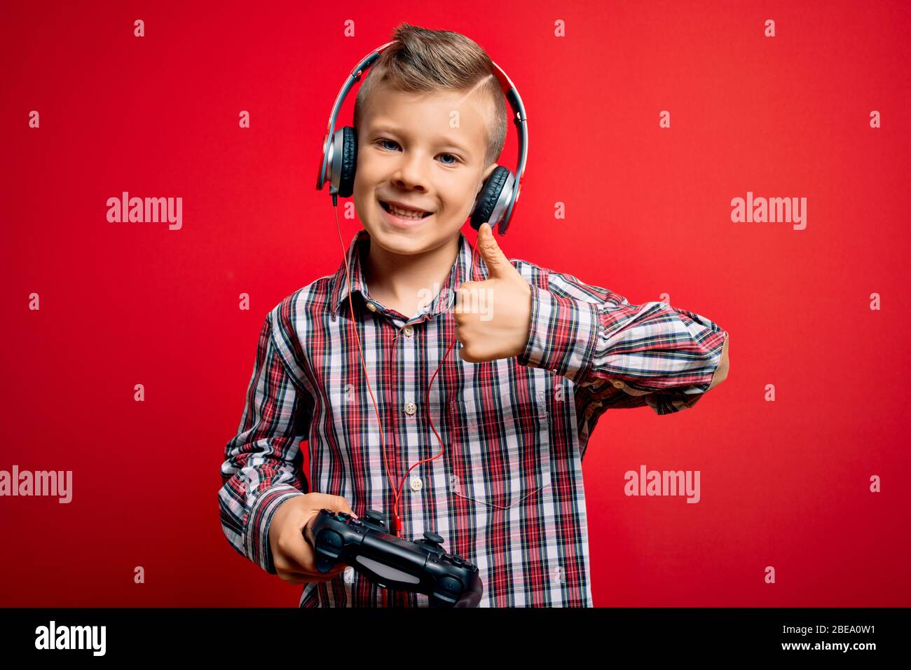 Young little caucasian gamer kid playing video games using gamepad ...
