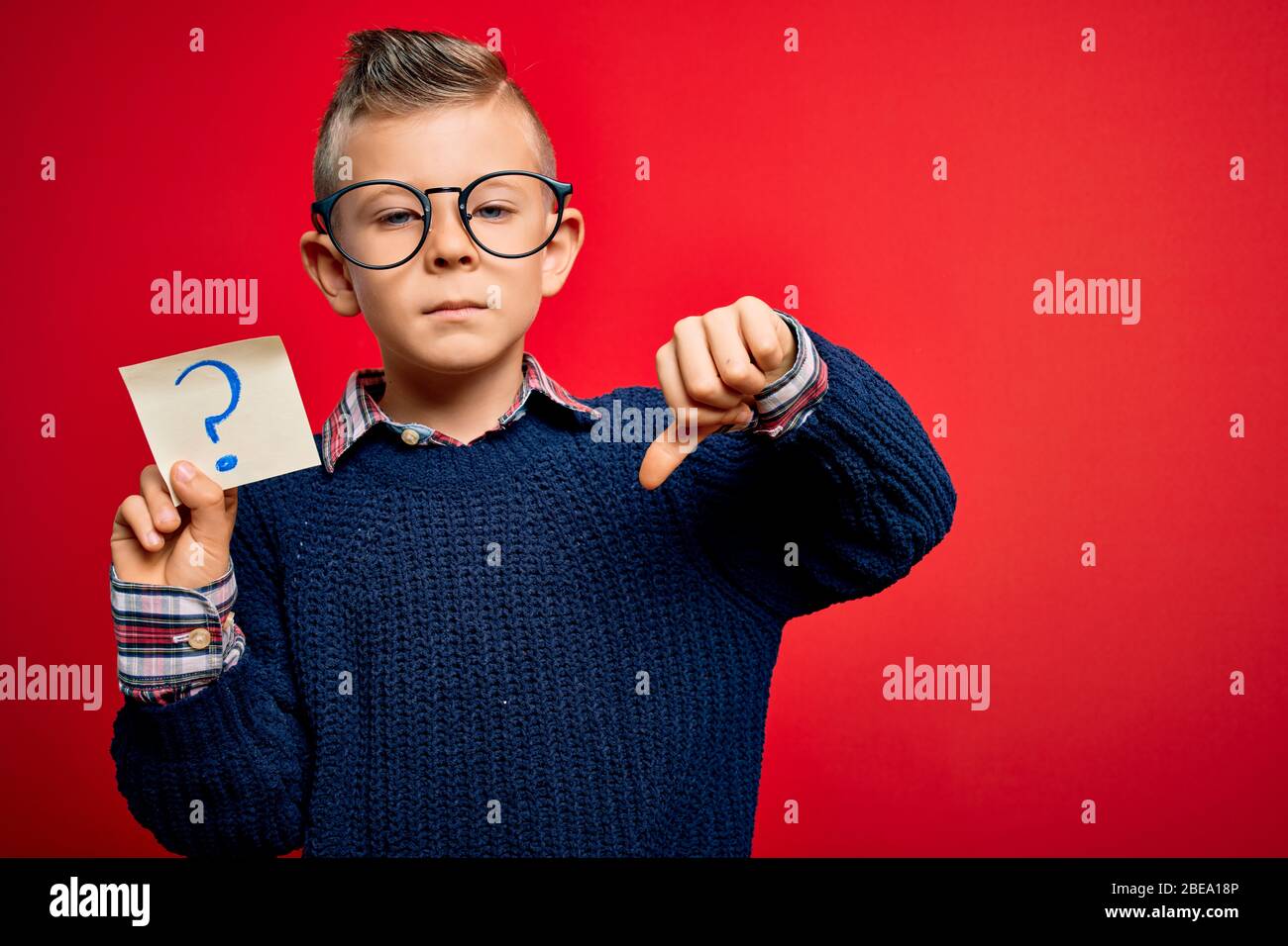 Young little caucasian kid wearing glasses holding paper note with ...