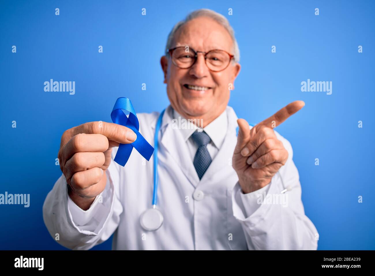 Grey haired senior doctor man holding colon cancer awareness blue ...
