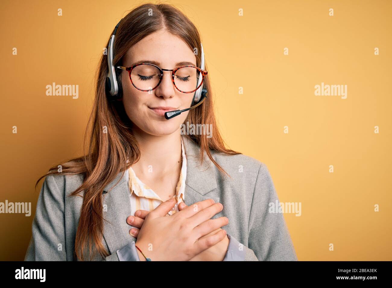Young redhead call center agent woman overworked wearing glasses using ...