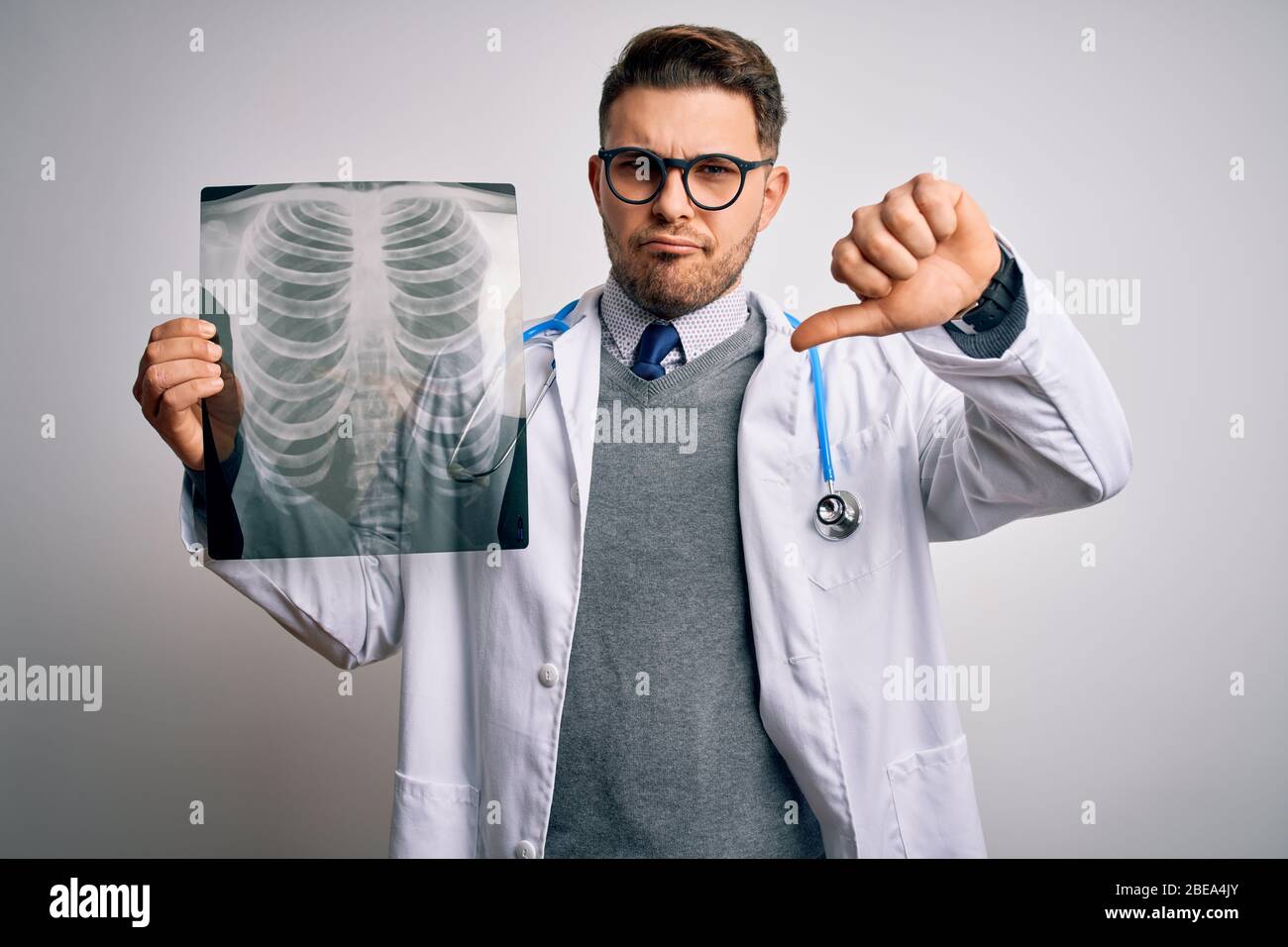 Young doctor man wearing medical coat looking at chest scan radiography ...
