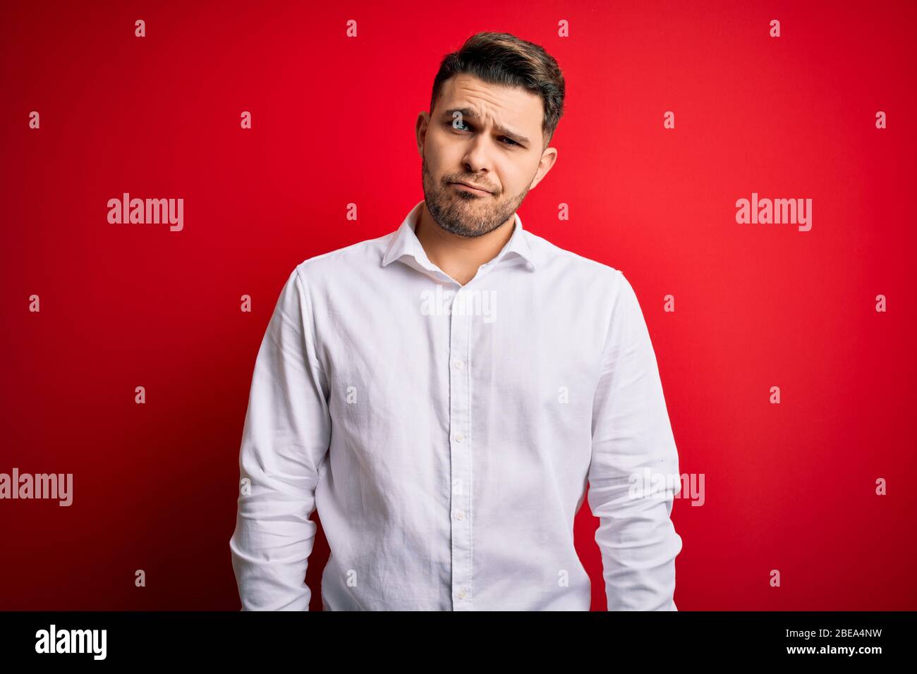 Young business man with blue eyes wearing elegant shirt standing over ...
