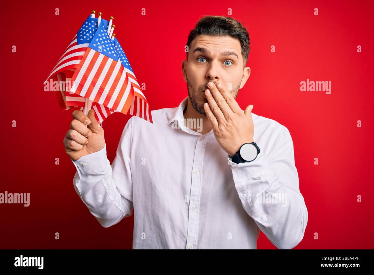 Young man with blue eyes holding flag of united states of america over ...