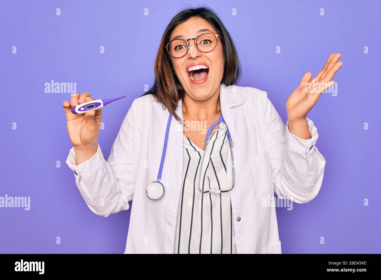Professional doctor woman showing medical thermometer over purple ...
