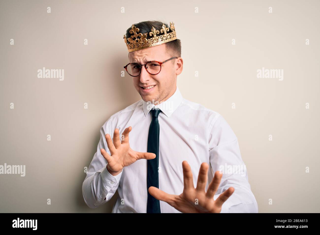 Young handsome caucasian business man wearing golden crown over ...