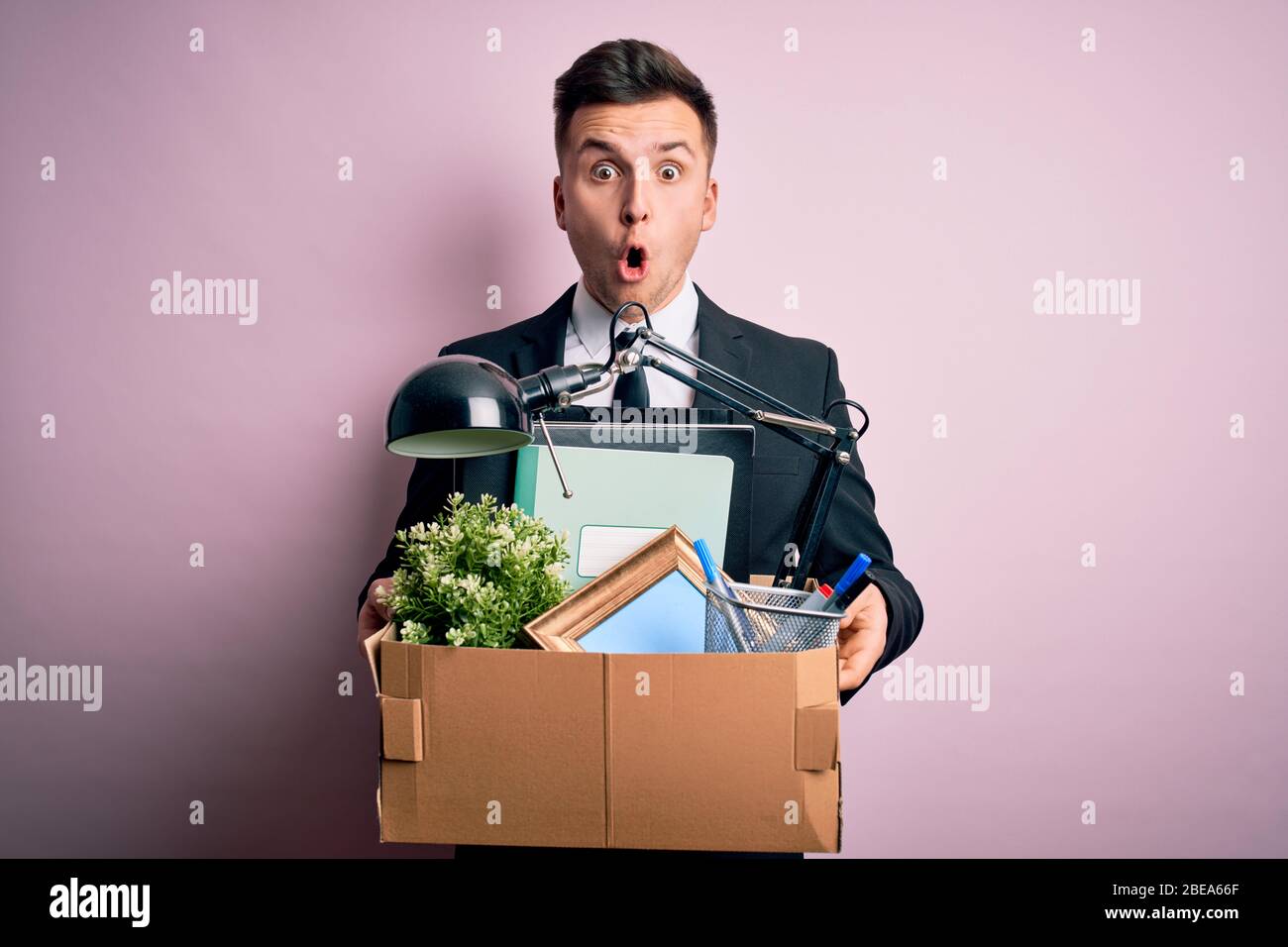 Young handsome caucasian business man holding cardboard box ...