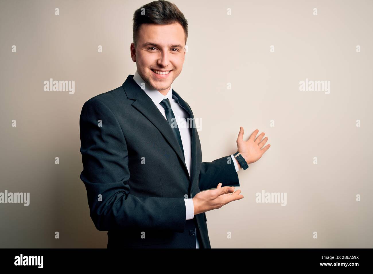 Young handsome business man wearing elegant suit and tie over isolated ...