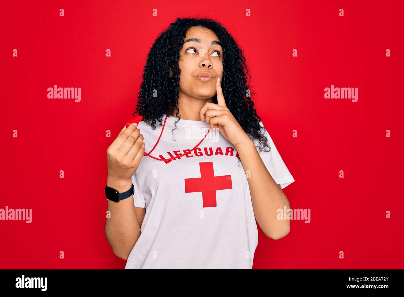 Young african american curly lifeguard woman wearing t-shirt with red ...