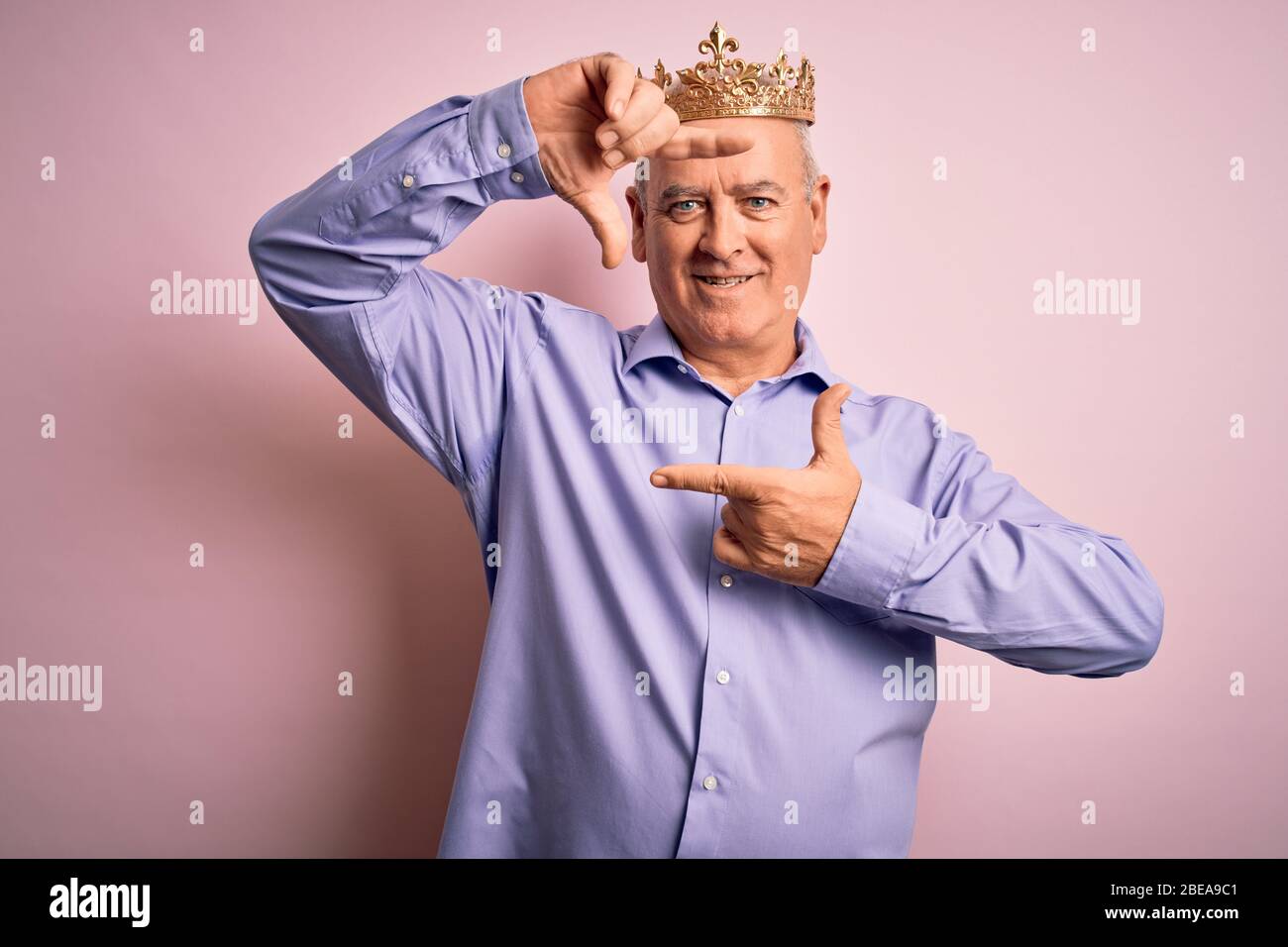 Middle age hoary man wearing golden crown of king standing over ...