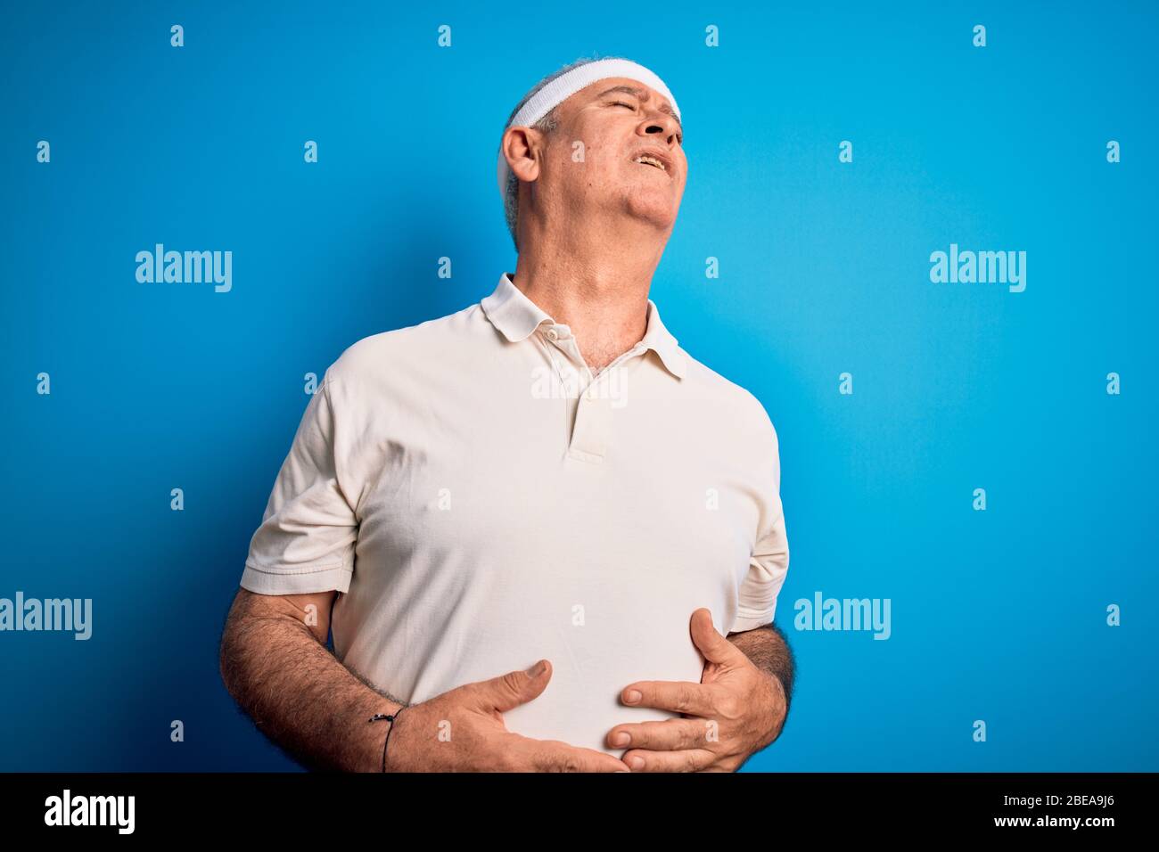 Middle age hoary sportsman doing sport wearing sportswear over isolated ...