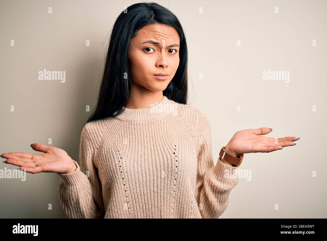 Young beautiful chinese woman wearing casual sweater over isolated ...