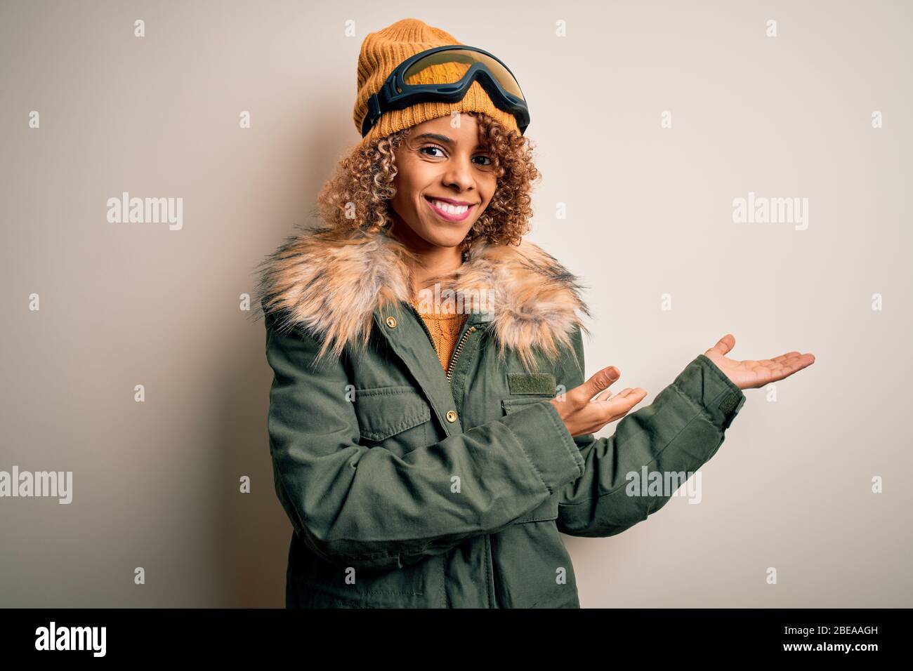Young african american skier woman with curly hair wearing snow ...