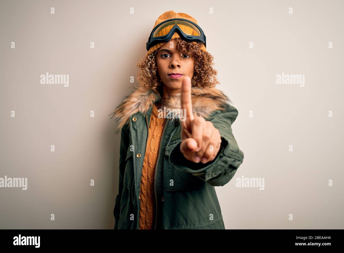Young african american skier woman with curly hair wearing snow ...