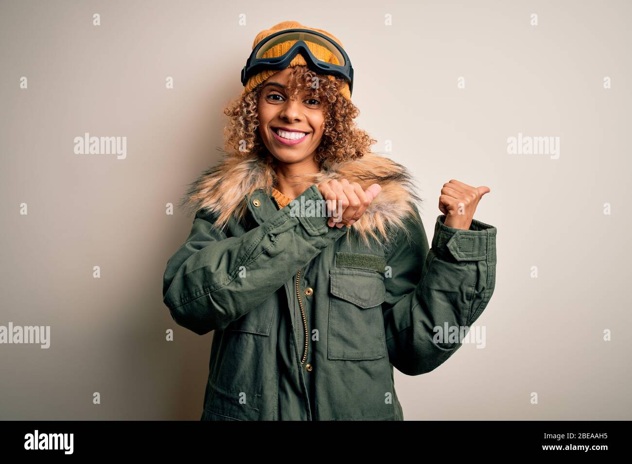 Young african american skier woman with curly hair wearing snow ...