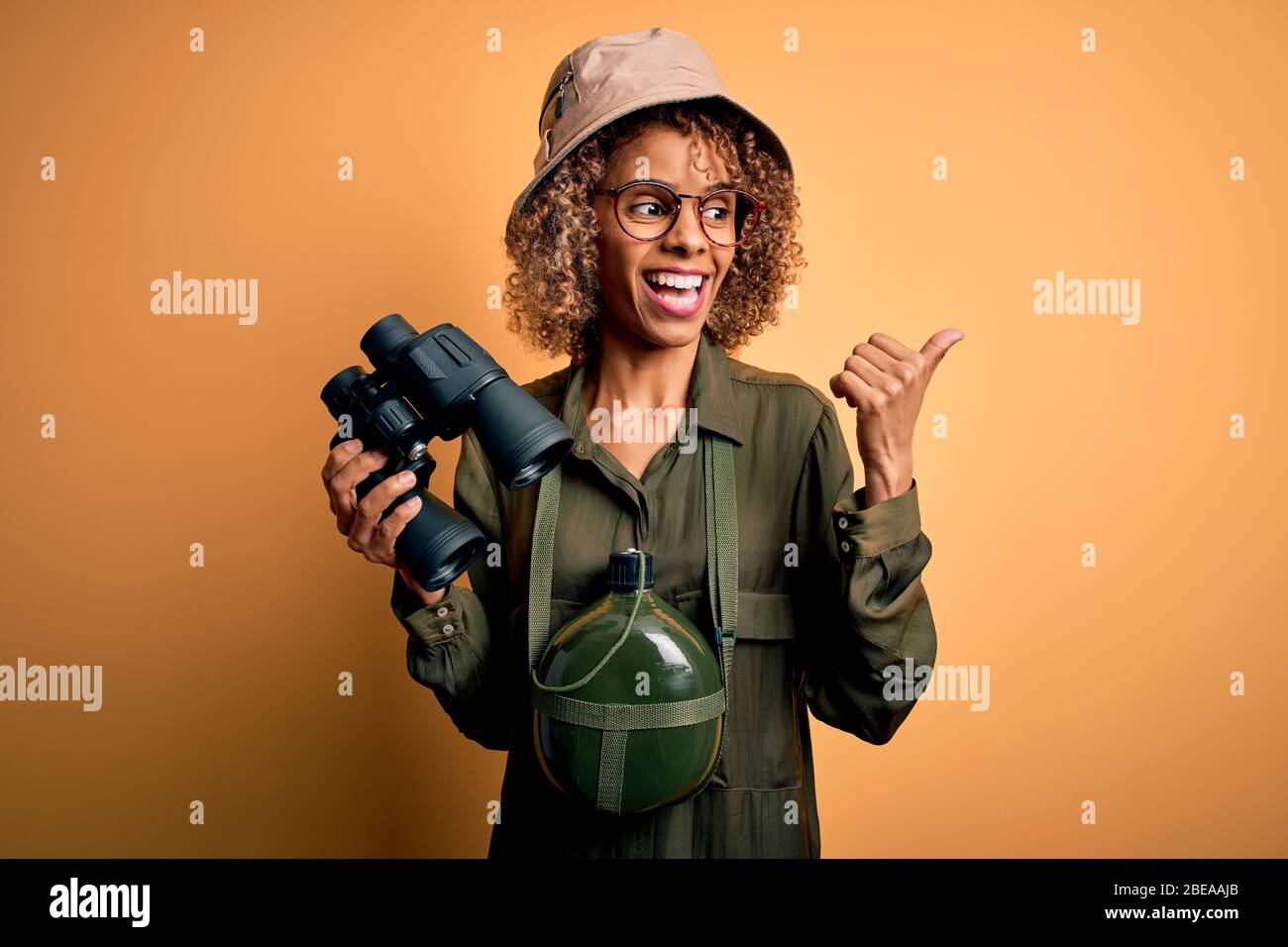 African american tourist woman wearing explorer hat and water canteen ...