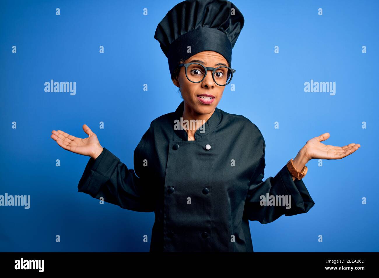 Young african american chef woman wearing cooker uniform and hat over ...