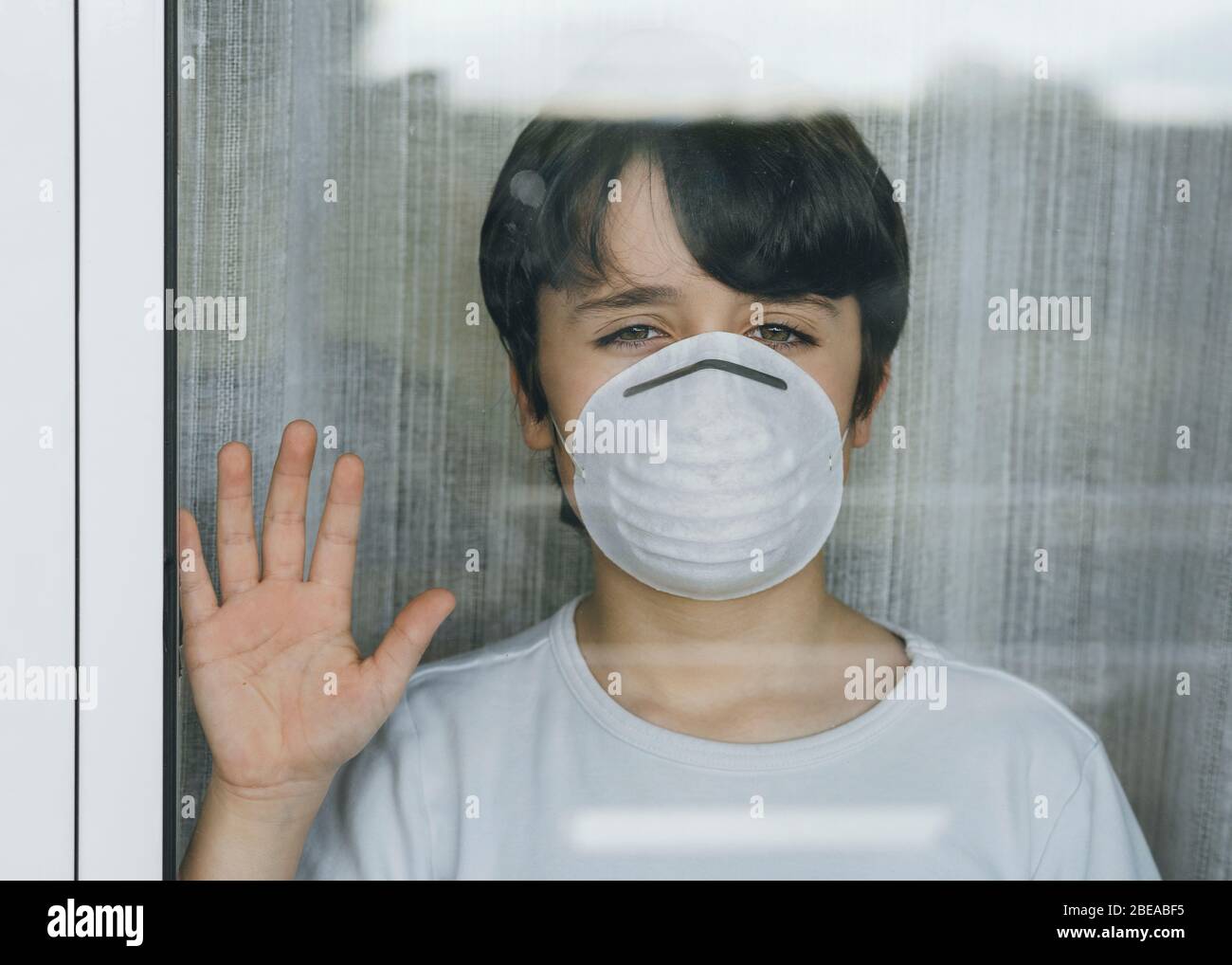 Quarantined child by the Coronavirus pandemic with mask medical looking ...